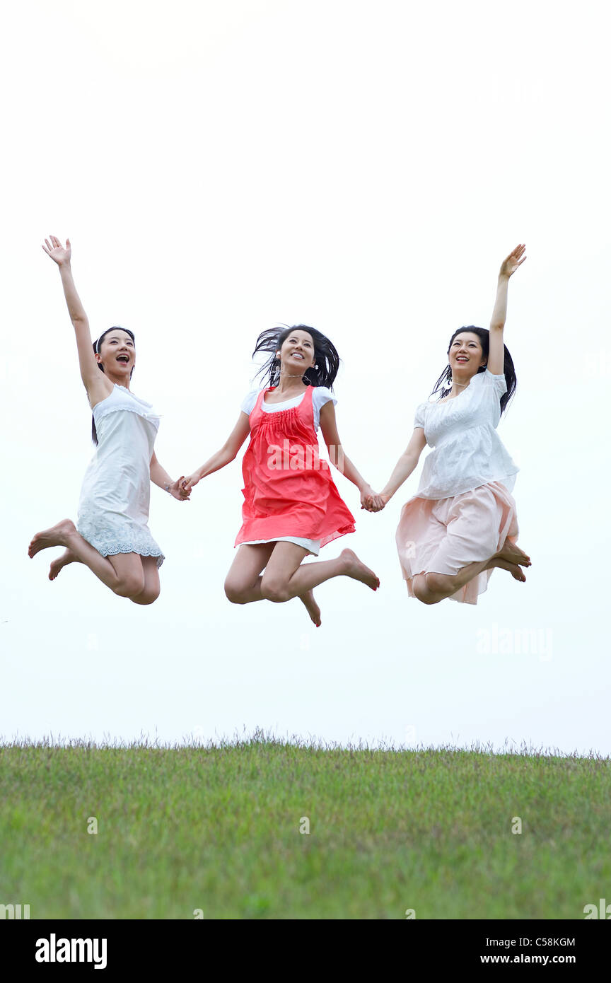 Young women jumping on grass Stock Photo - Alamy