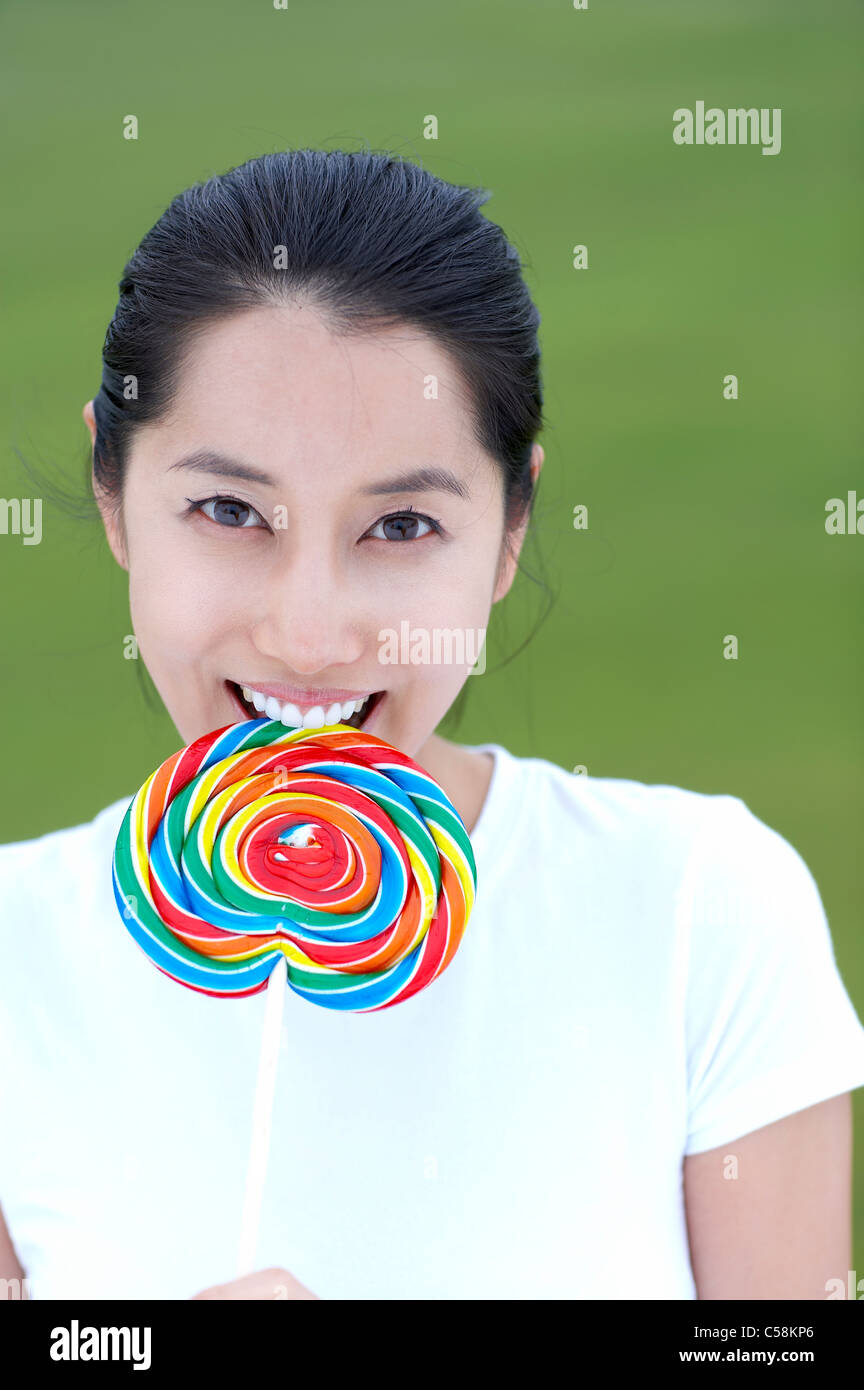 Portrait of young woman eating lollipop Stock Photo - Alamy