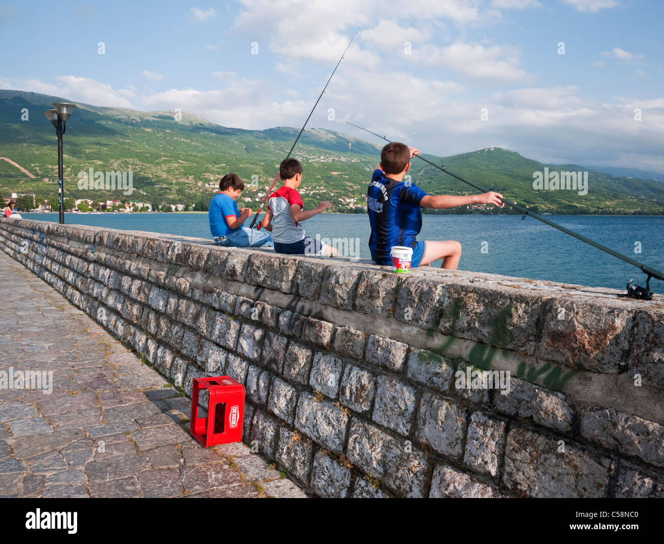 Young boys fishing in Lake Ohrid from Ohrid harbour wall. Macedonia ...