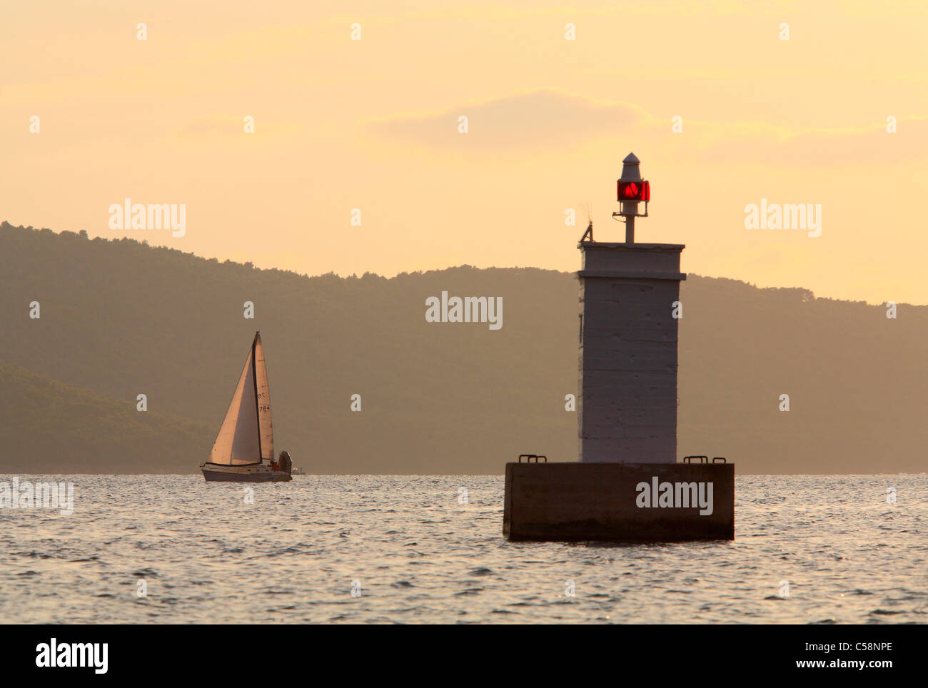 Lighthouse and sailboat Stock Photo - Alamy