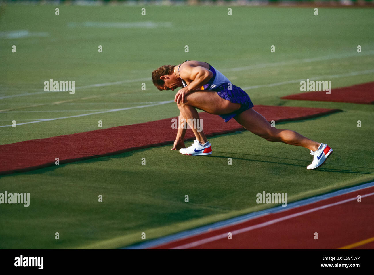 Male runners stretching before competing in a track race Stock Photo ...