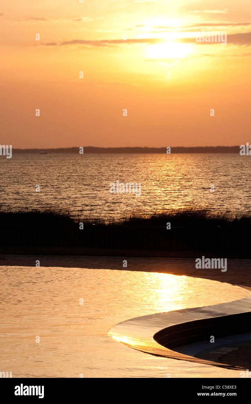 Infinity pool next to ocean at sunset Stock Photo - Alamy