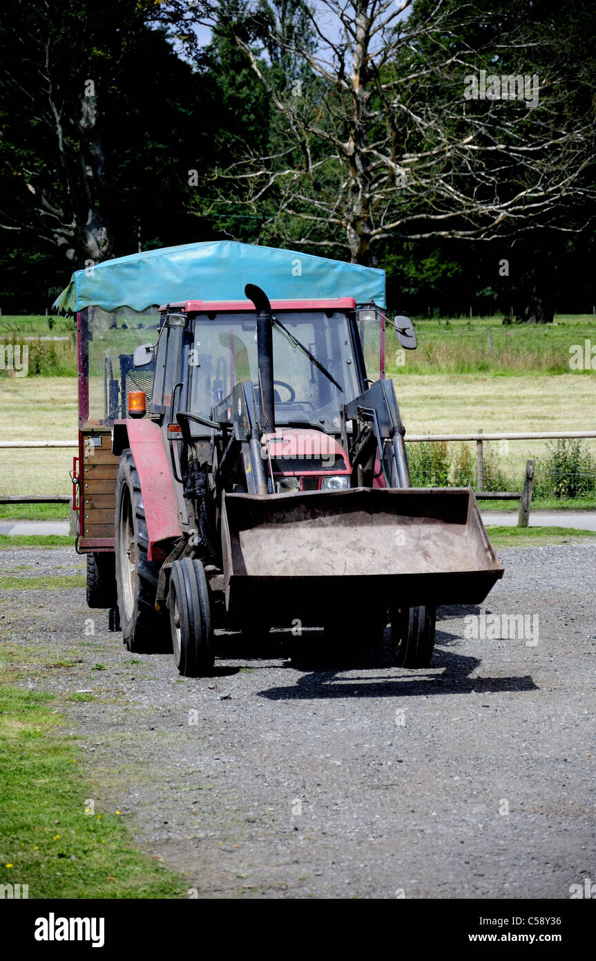 Well used tractor with trailer parked. Bucket fitted at front broken ...