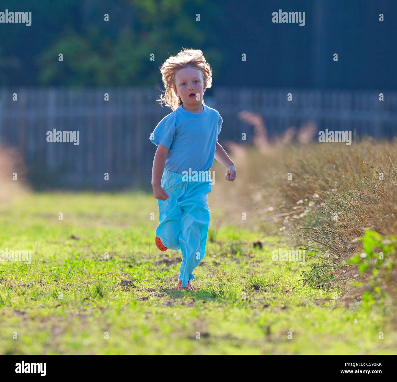 boy with long blond hair running toward the camera Stock Photo - Alamy