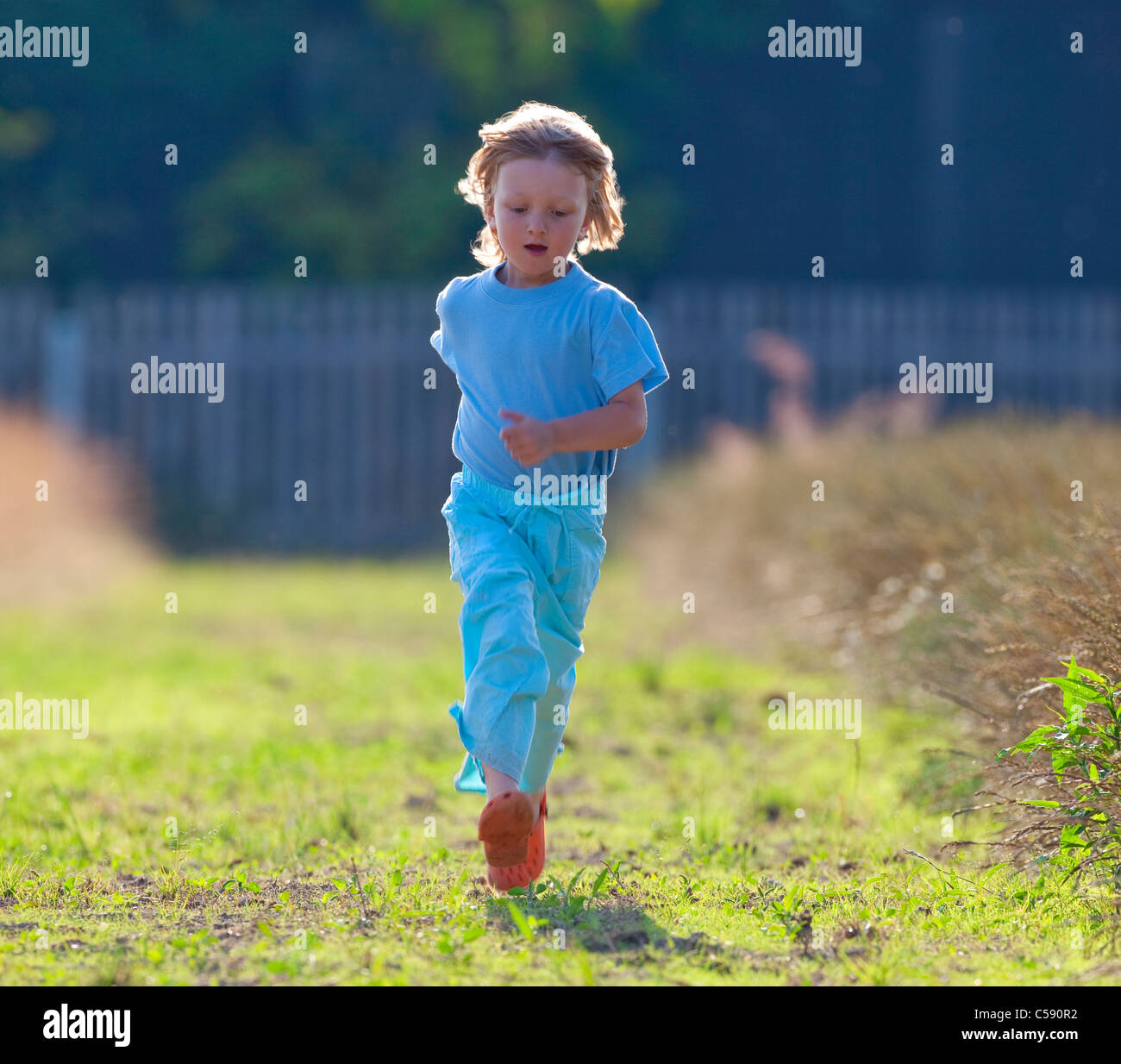 boy with long blond hair running toward the camera Stock Photo - Alamy