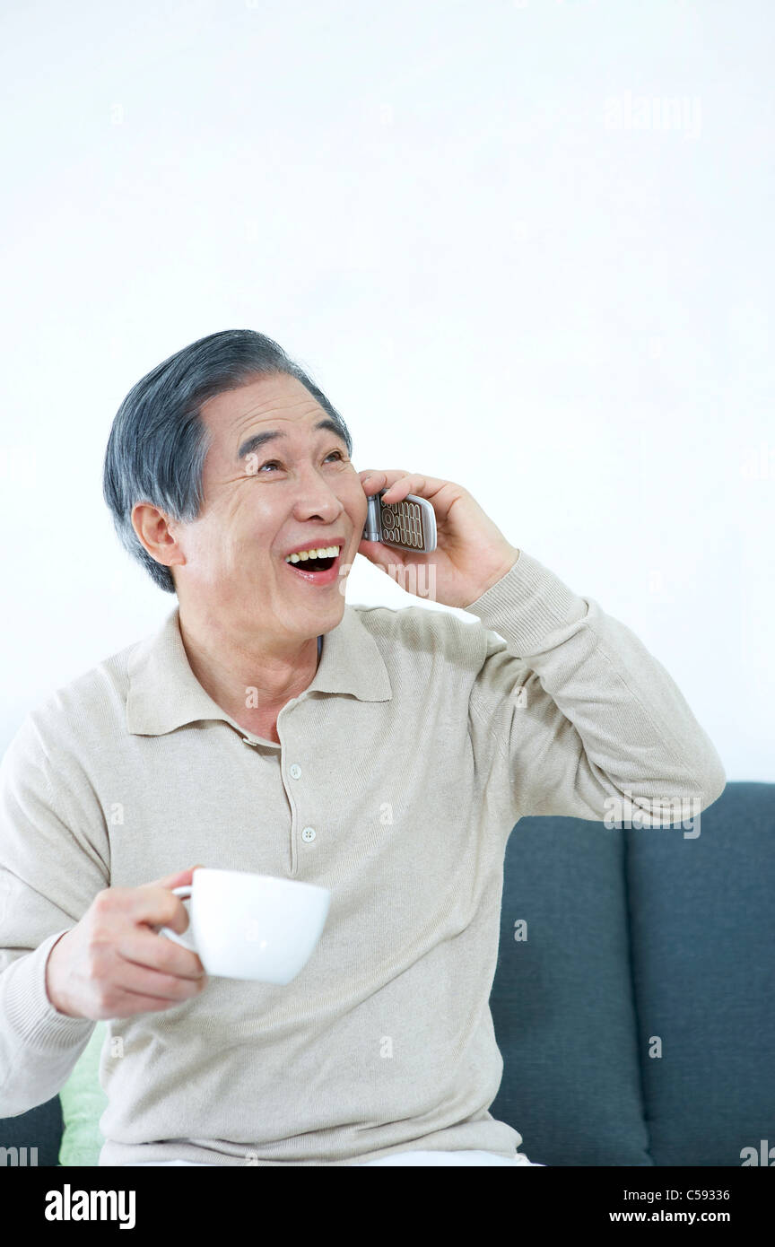 Senior man sitting on sofa Stock Photo - Alamy
