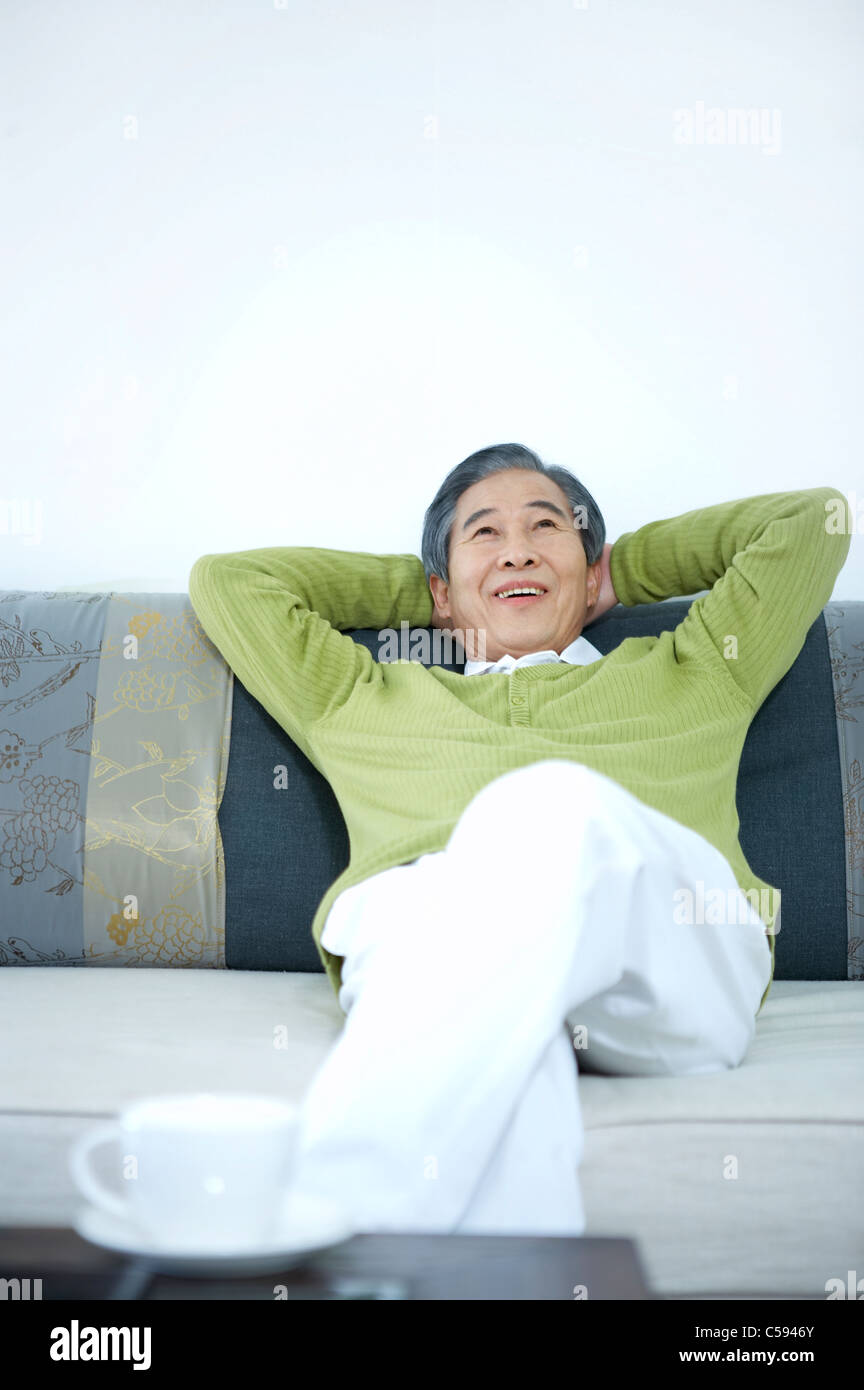 Senior man sitting on sofa Stock Photo - Alamy