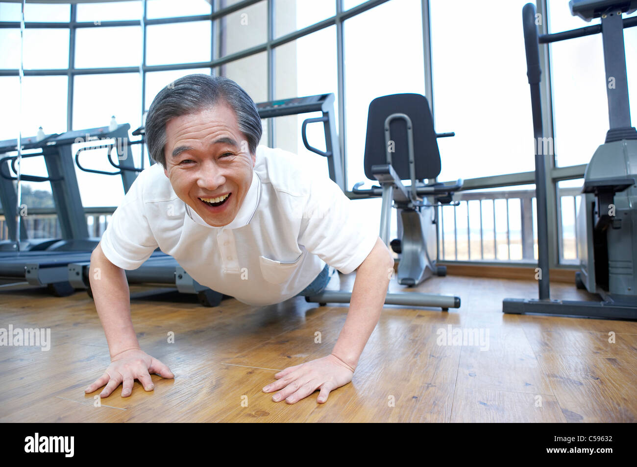 Portrait of senior man in gym doing push-ups Stock Photo - Alamy