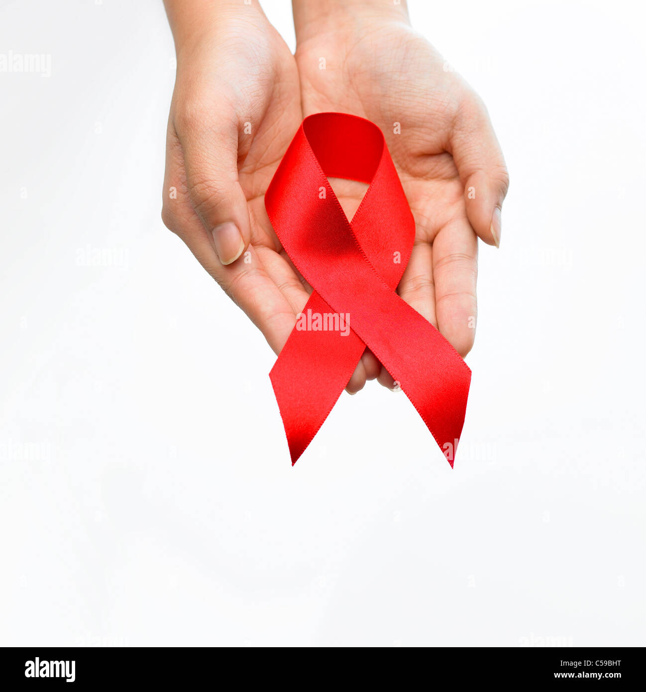 Close-up of person's hand holding red ribbon the AIDS symbol Stock ...