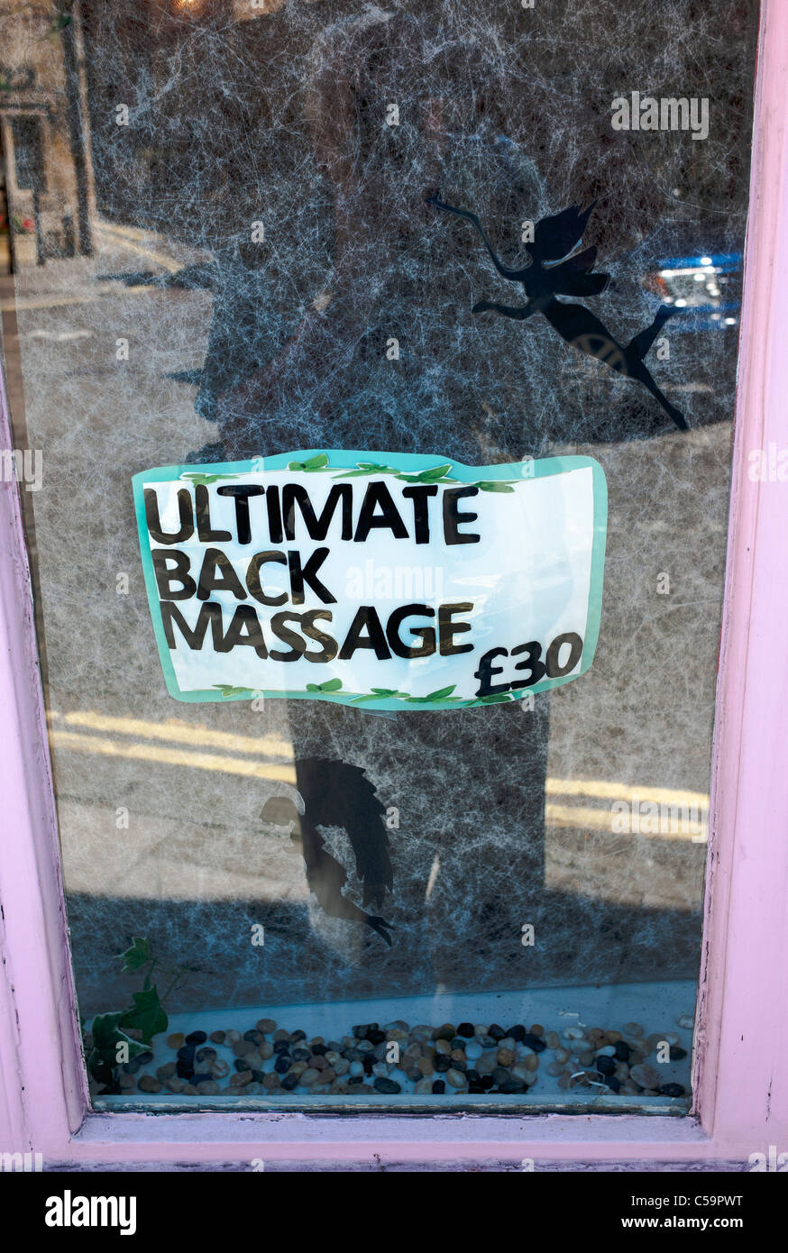 Sign in shop window promoting back massage treatment Stock Photo - Alamy