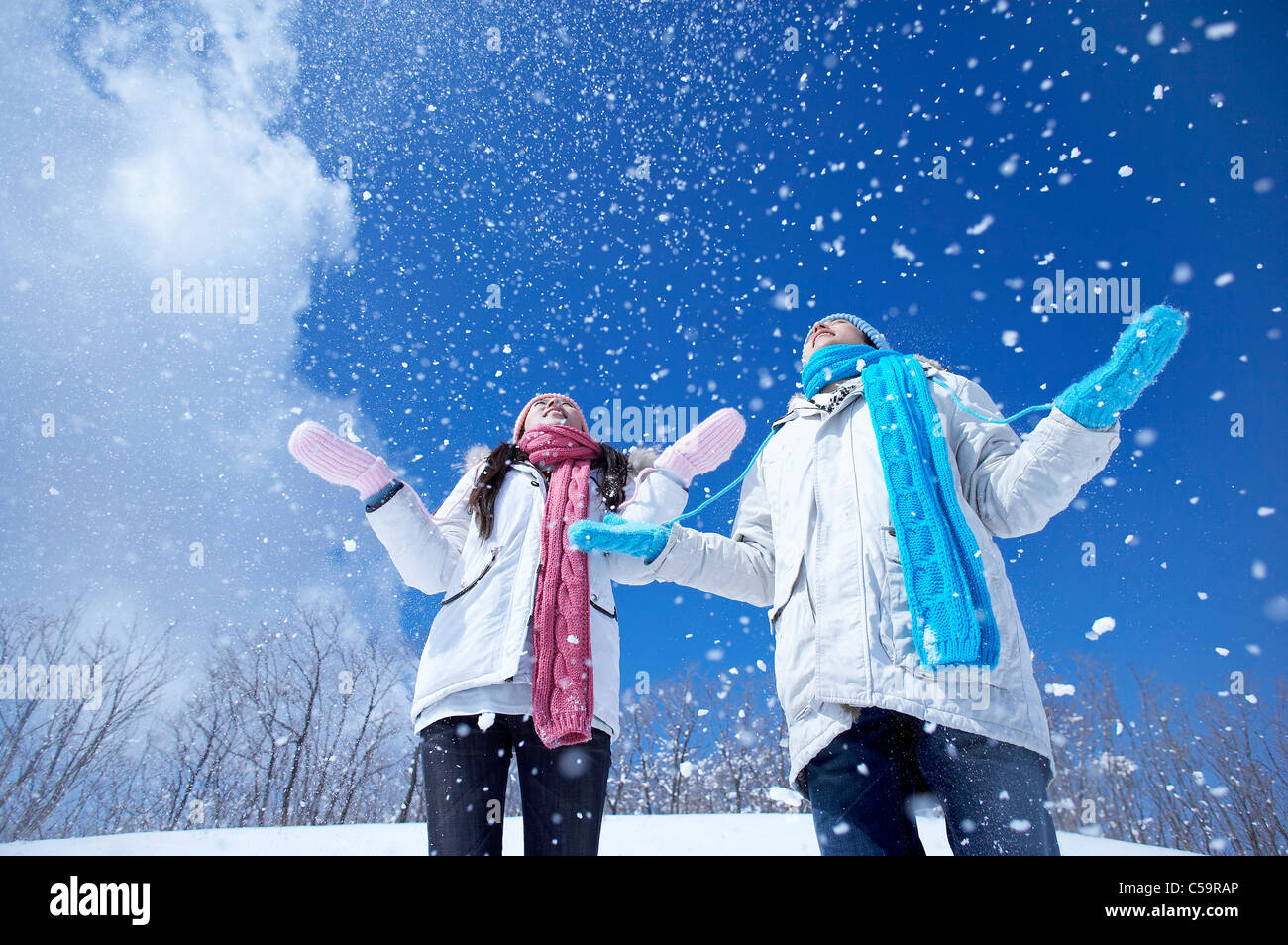 Young man and woman enjoying snowfall Stock Photo - Alamy