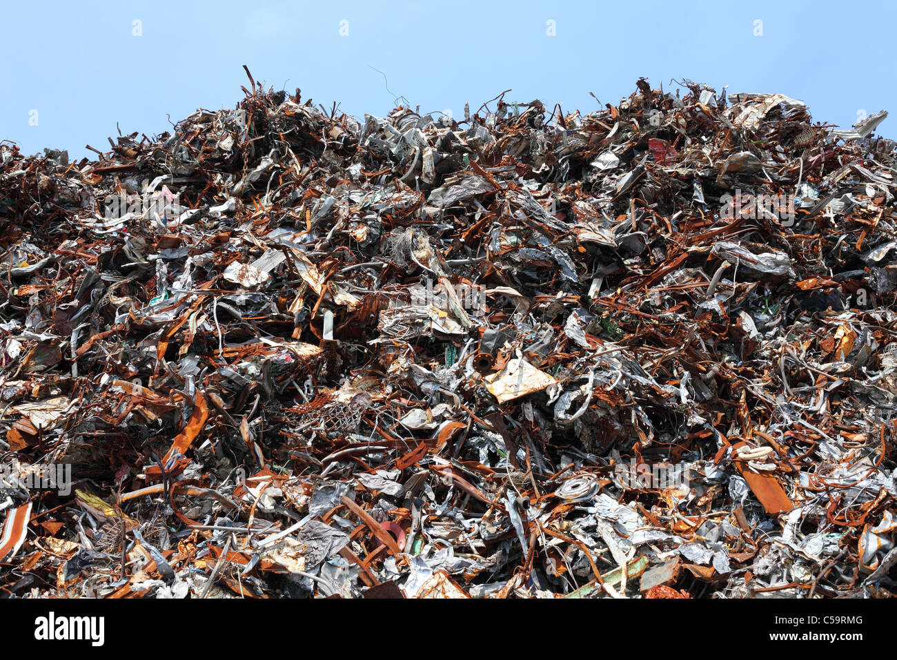 Stack of scrap metal against blue sky Stock Photo - Alamy