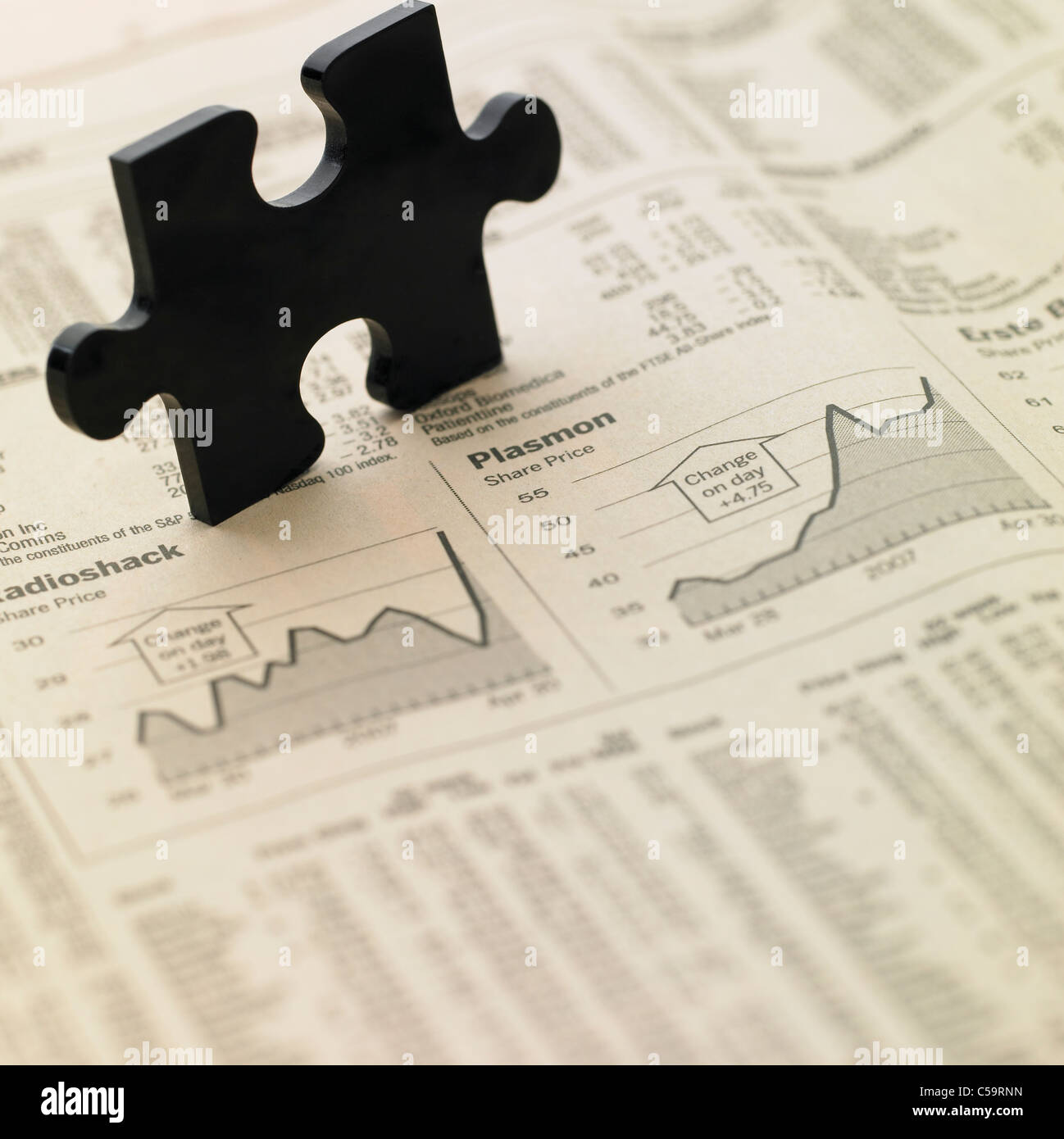 Jigsaw Puzzle Piece on Financial Newspaper Stock Photo - Alamy
