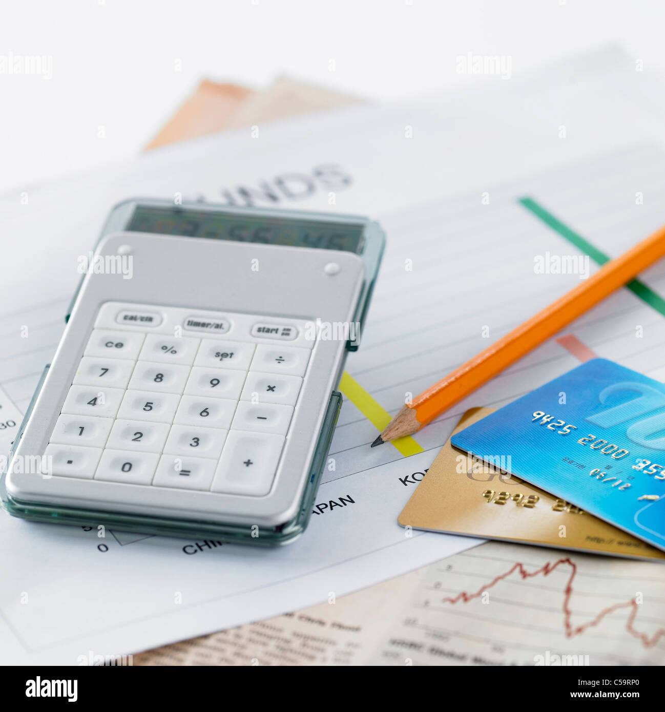 Calculator, pencil and credit cards on newspaper Stock Photo - Alamy