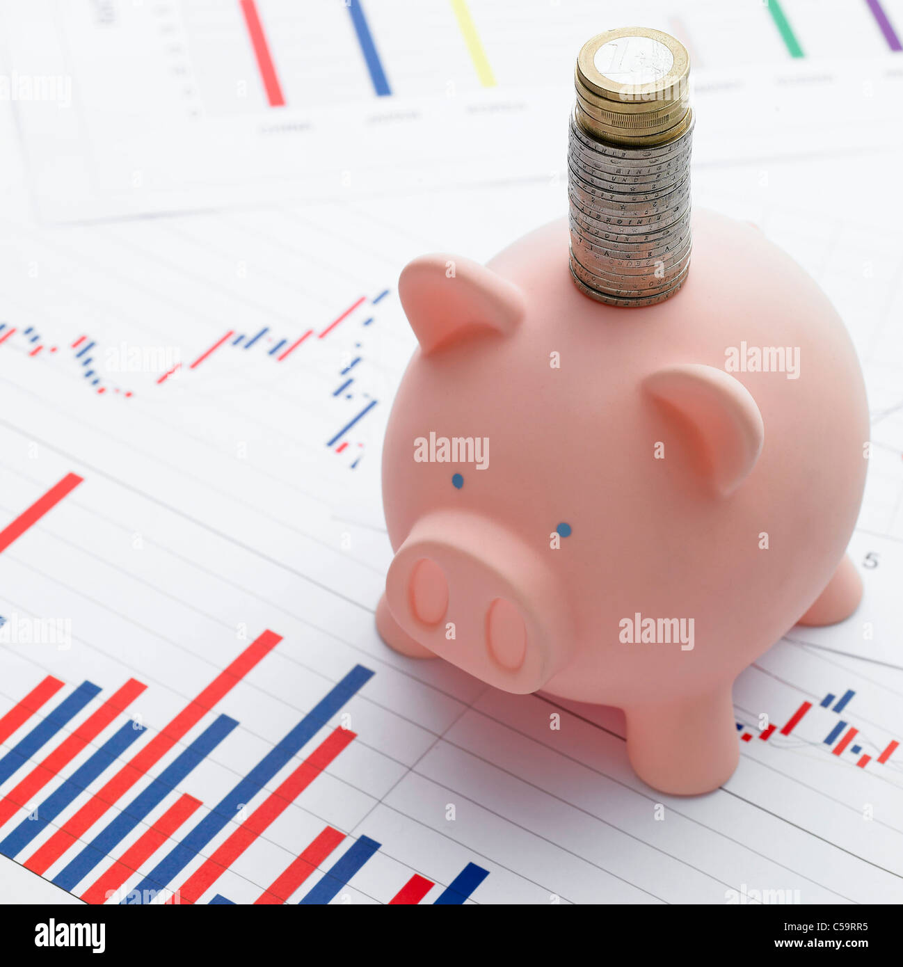 Coins stack on piggy bank, graph in background Stock Photo - Alamy