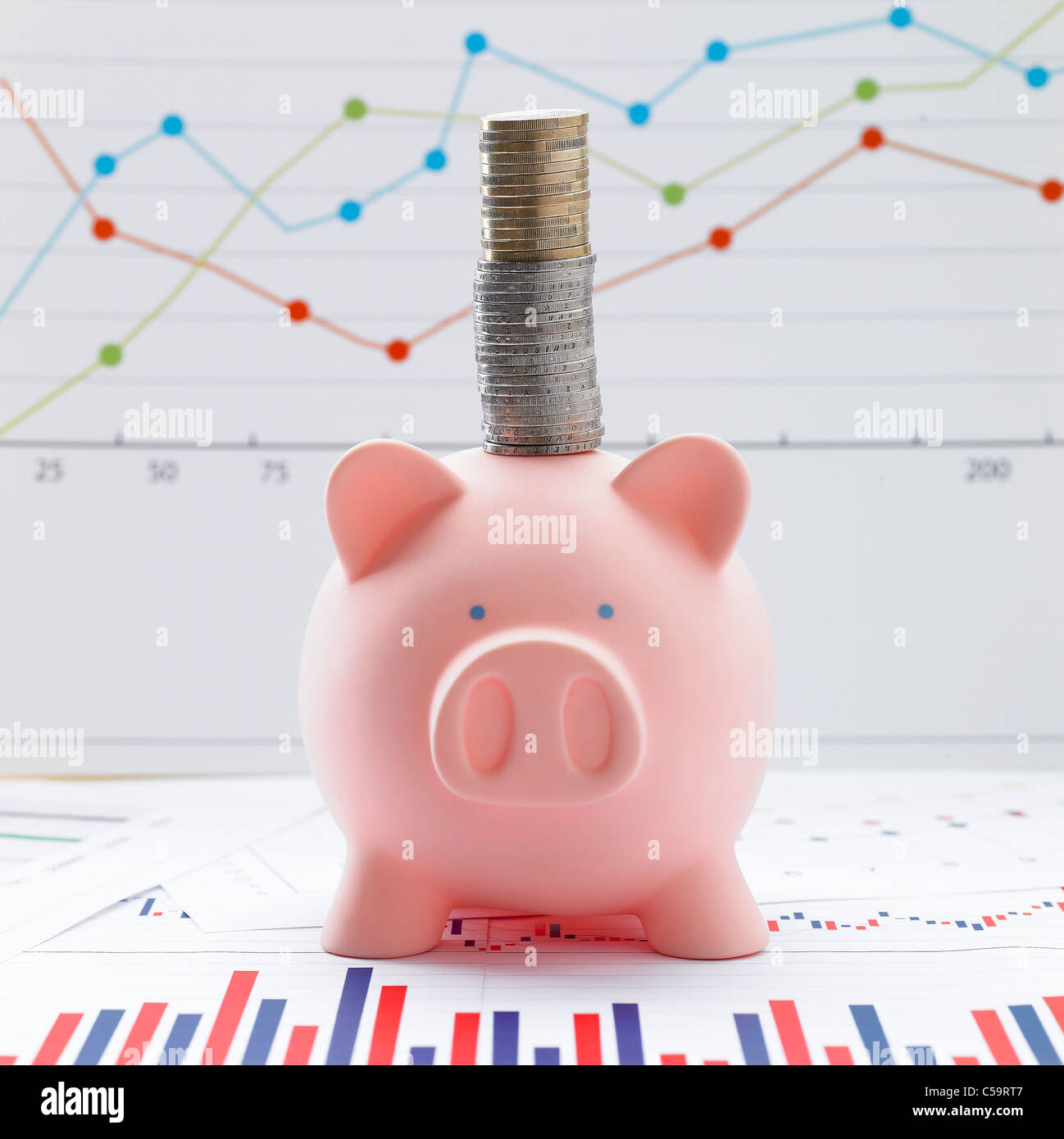 Coins stack on piggy bank, graph in background Stock Photo - Alamy
