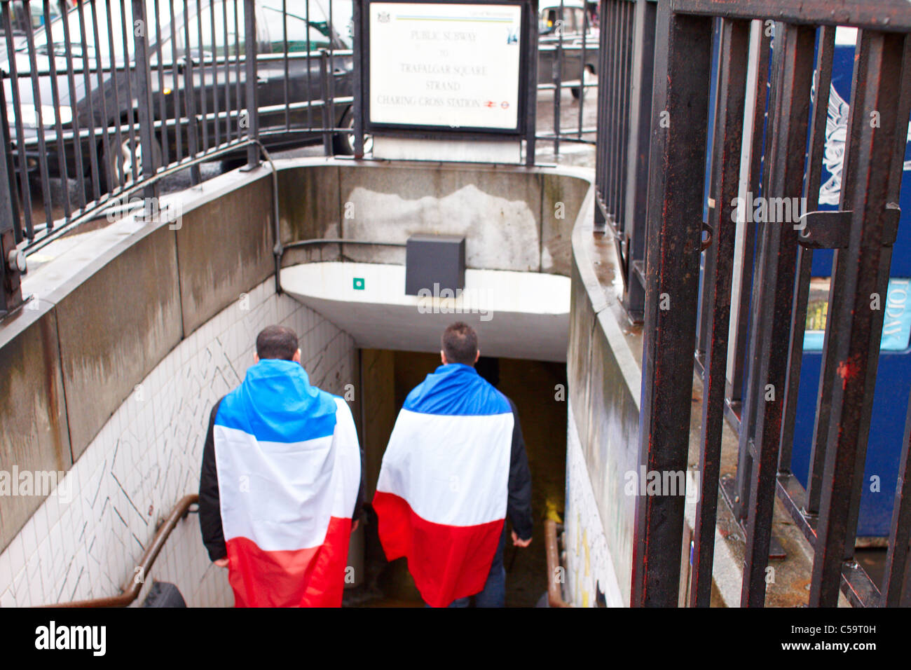 French rugby fans wrapped in national flags enter the Tube in London ...