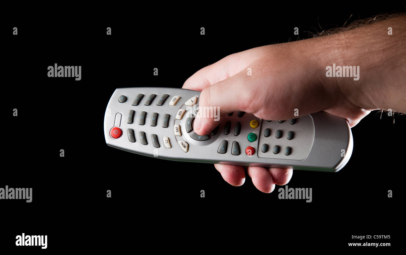 Hand holding a remote control isolated on black Stock Photo - Alamy