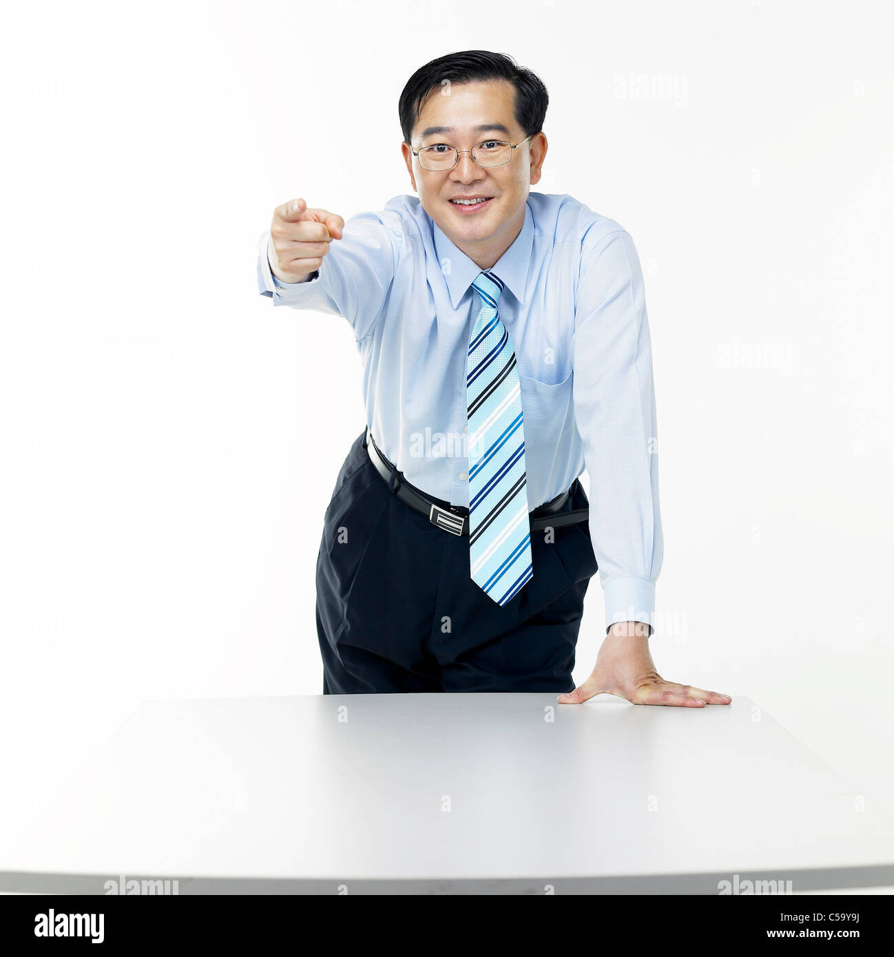 Businessman standing by table, pointing Stock Photo - Alamy