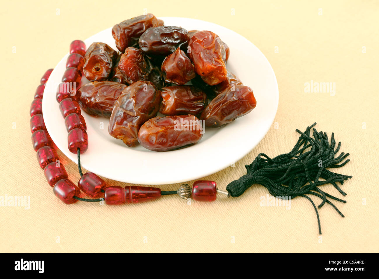 A plate of dates, eaten at fast-breaking in Ramadan, with a string of ...