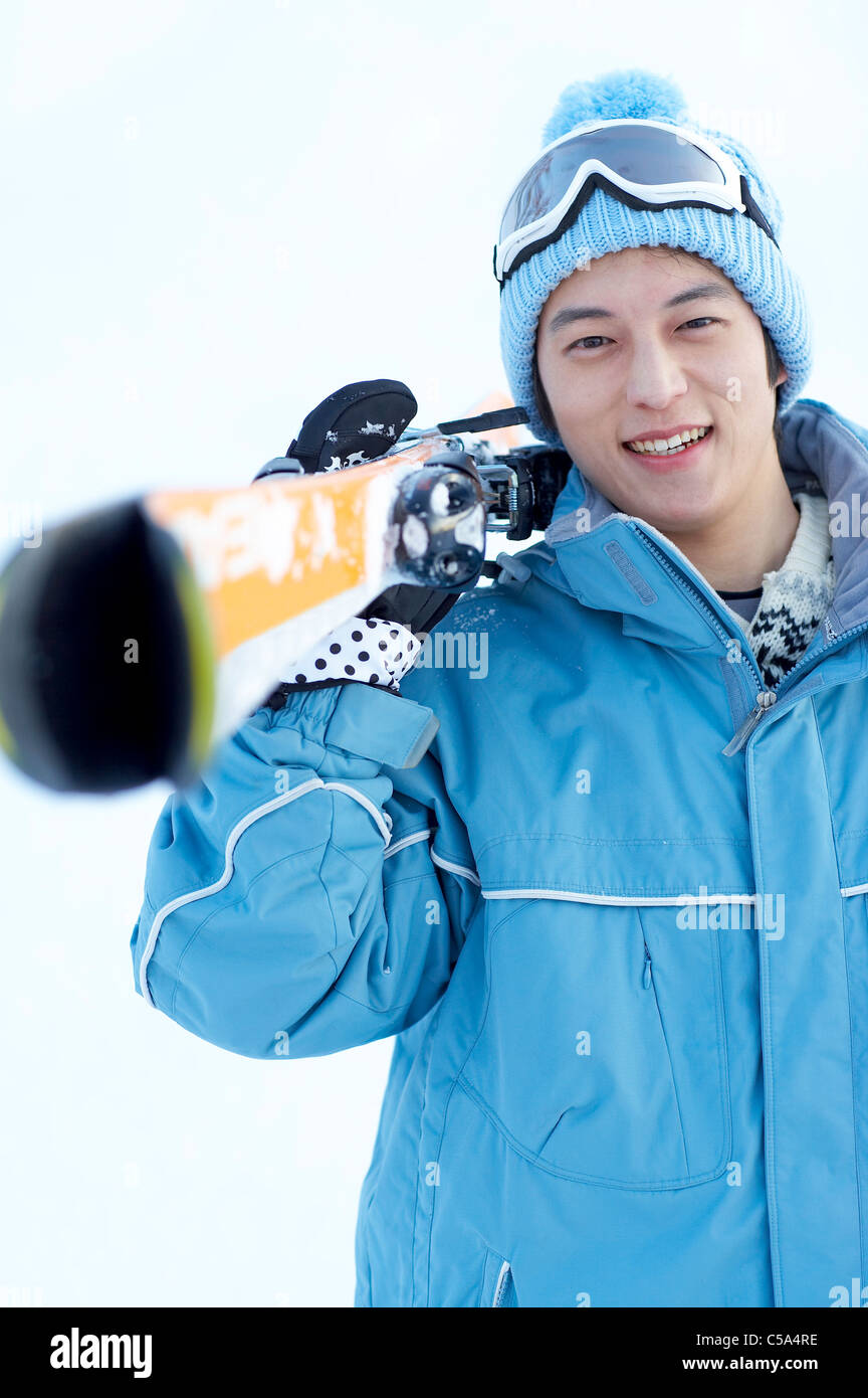 Young man holding alpine skies Stock Photo - Alamy