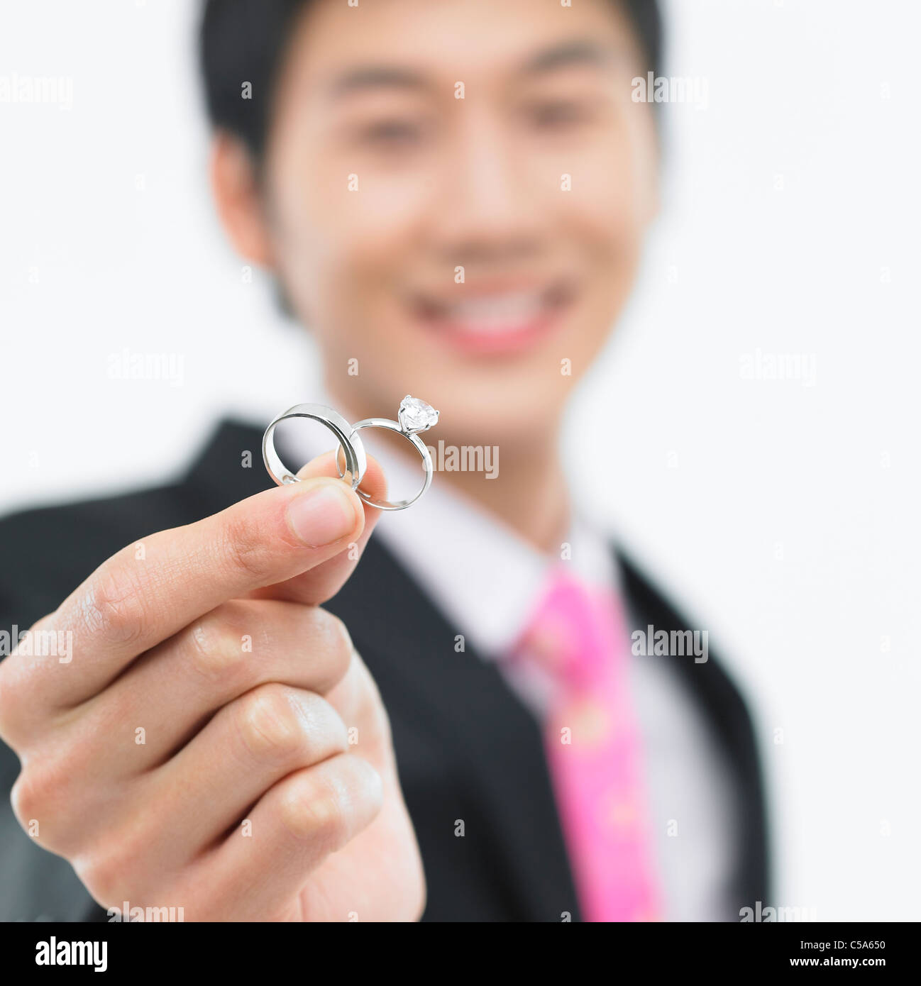 Portrait of young man holding ring Stock Photo - Alamy