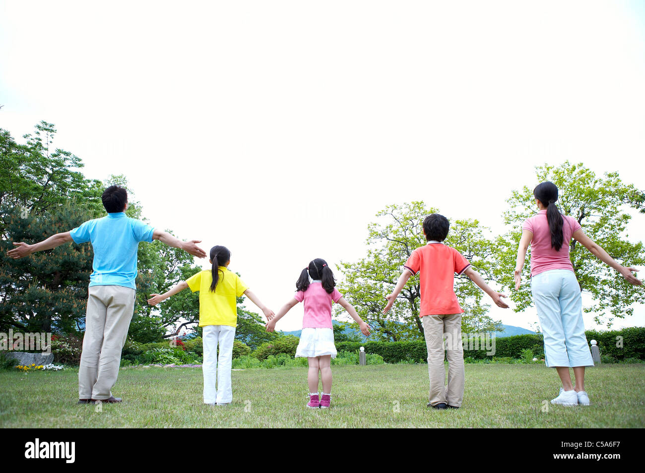 Rear view of Family standing in garden Stock Photo - Alamy