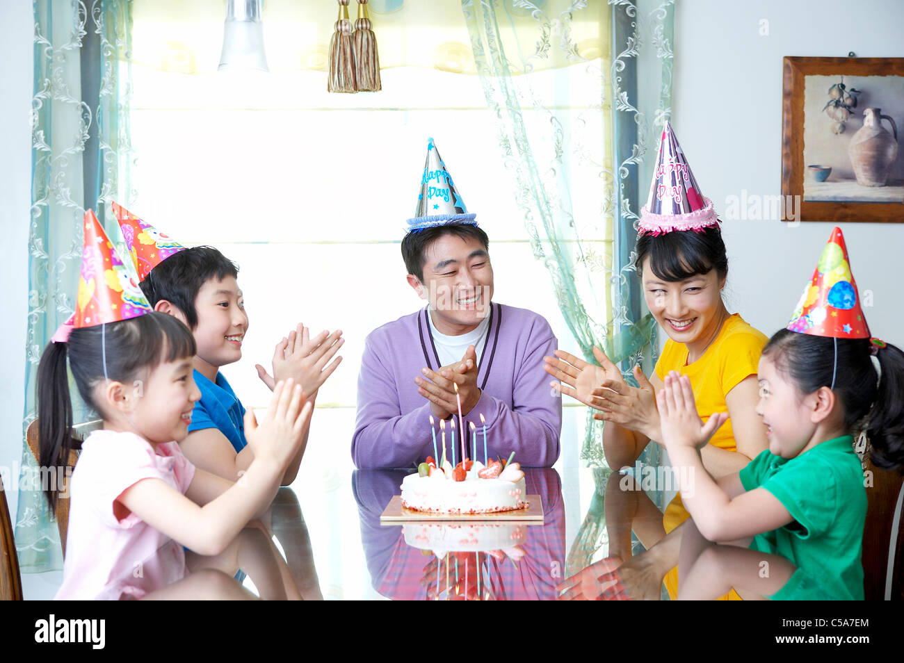 Family clapping at birthday party Stock Photo - Alamy