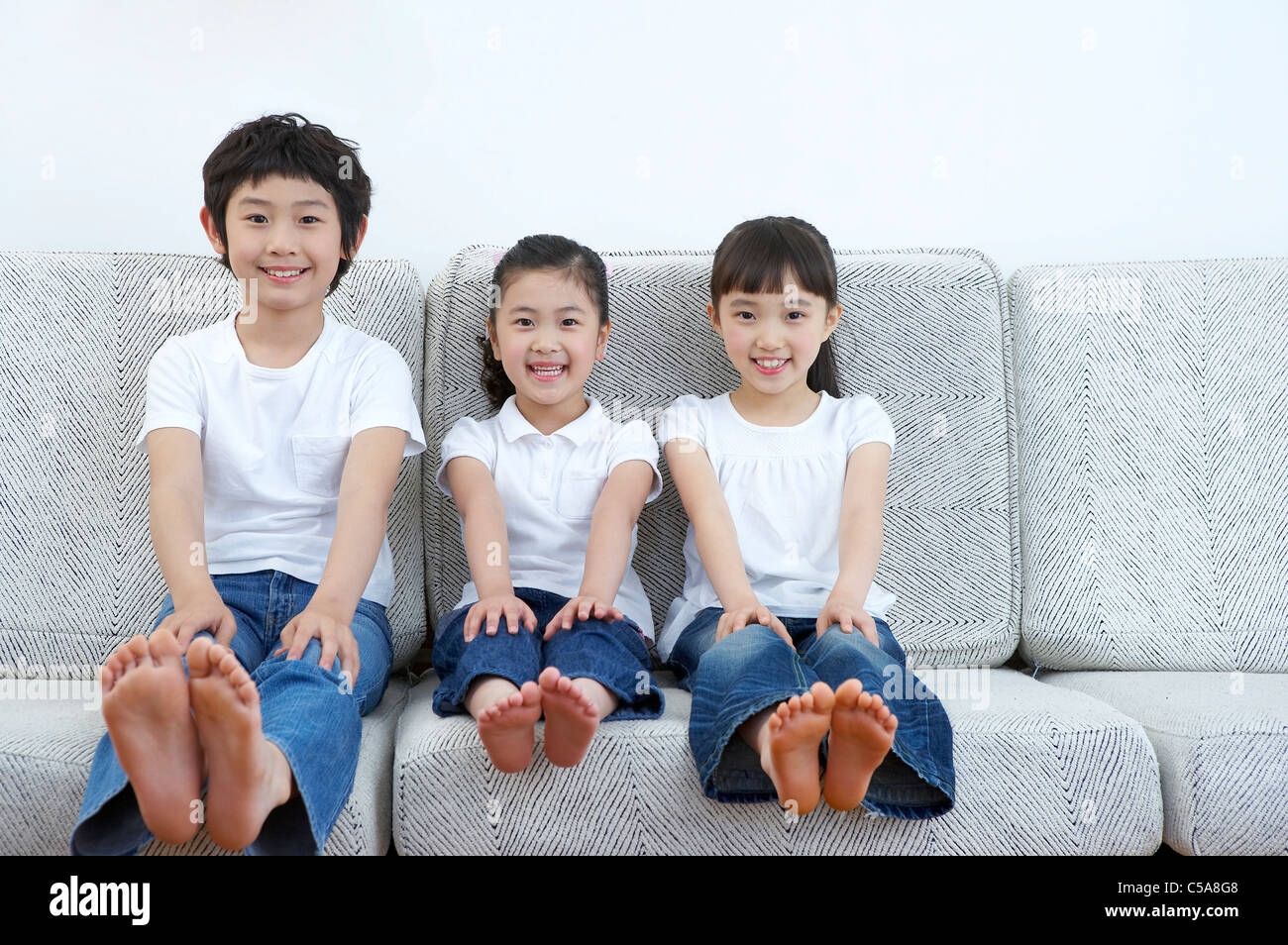 Portrait of children sitting on sofa Stock Photo - Alamy