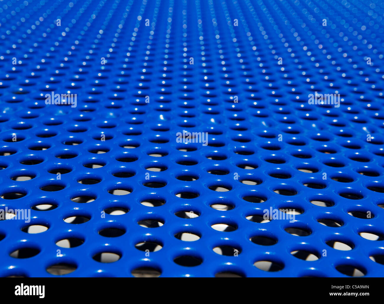 Bright blue metal grate that is part of a table done in diminishing ...