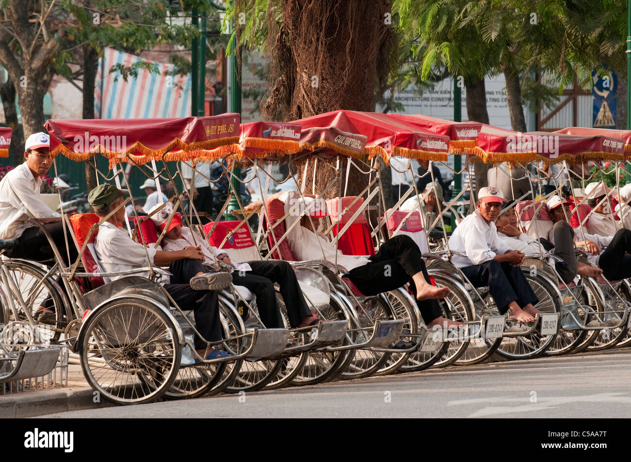 Rickshaw riders sitting in their cyclos at the Hanoi Opera House, Hanoi ...