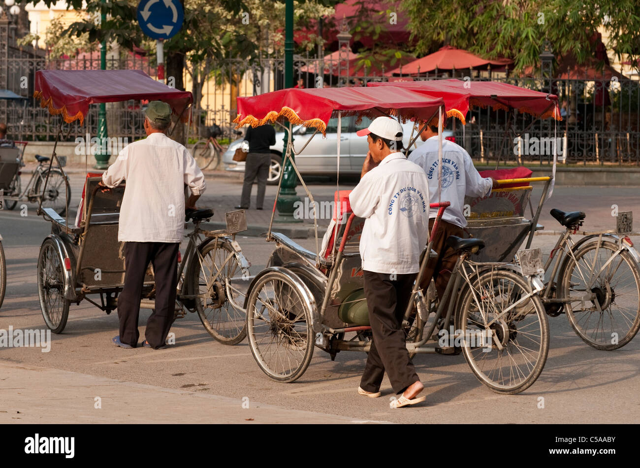 Rickshaw riders pushing their cyclos at the Hanoi Opera House, Hanoi ...