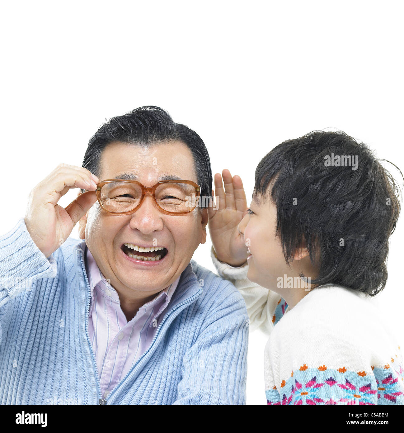 Grandson whispering in grandfather's ears Stock Photo - Alamy