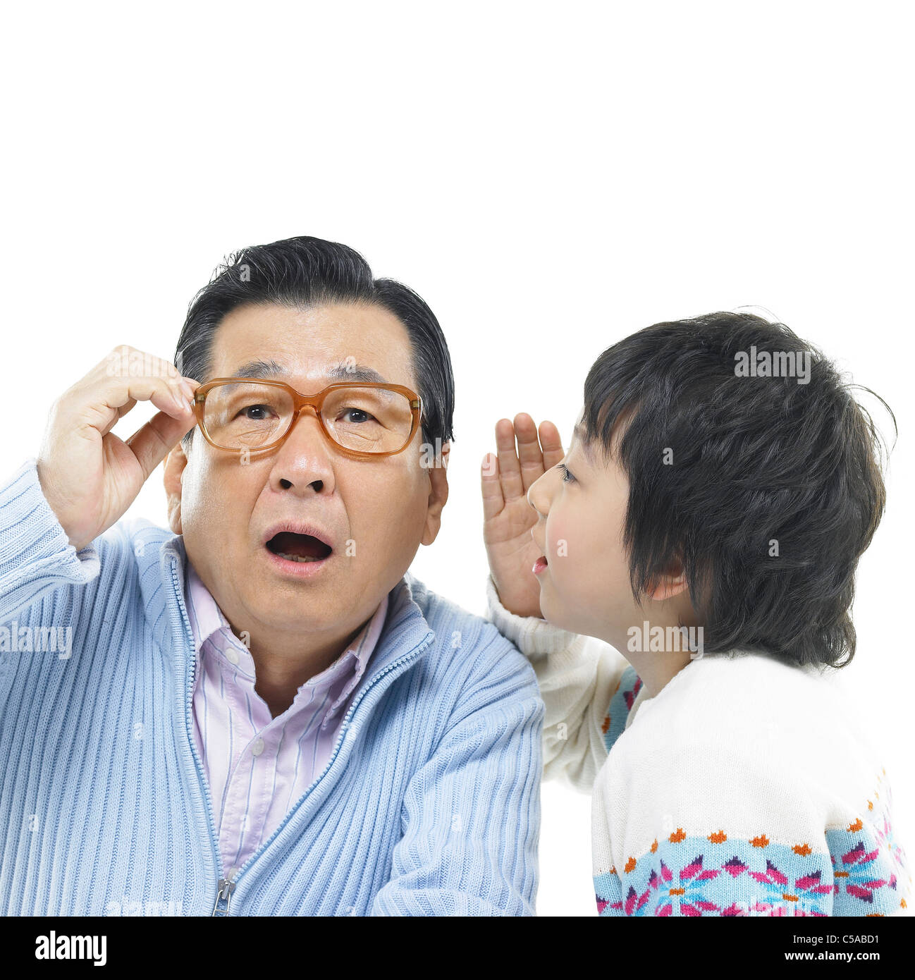 Grandson whispering in grandfather's ears Stock Photo - Alamy