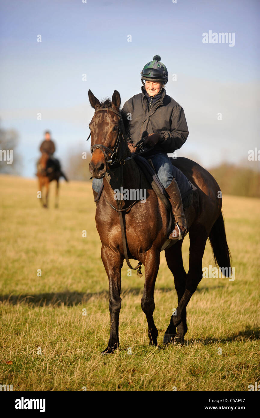 Work riders exercising racehorses at a stable in Gloucestershire UK ...