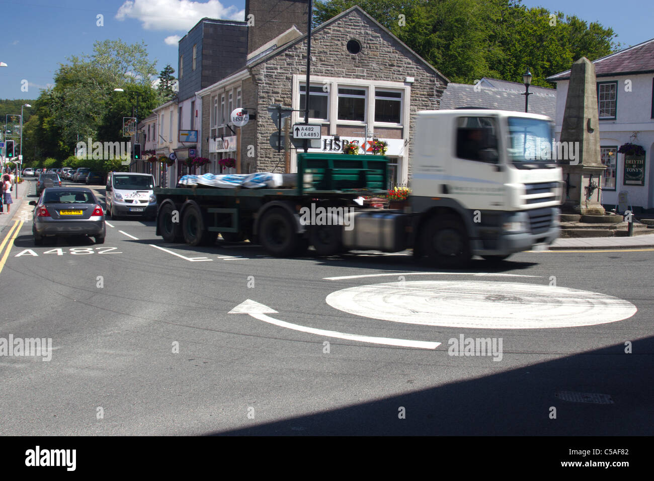 Lorry negotiating mini-roundabout on a narrow street Stock Photo - Alamy
