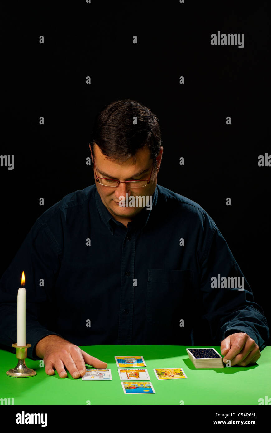 Tarot reader having a concentrated look at a spread of cards Stock ...