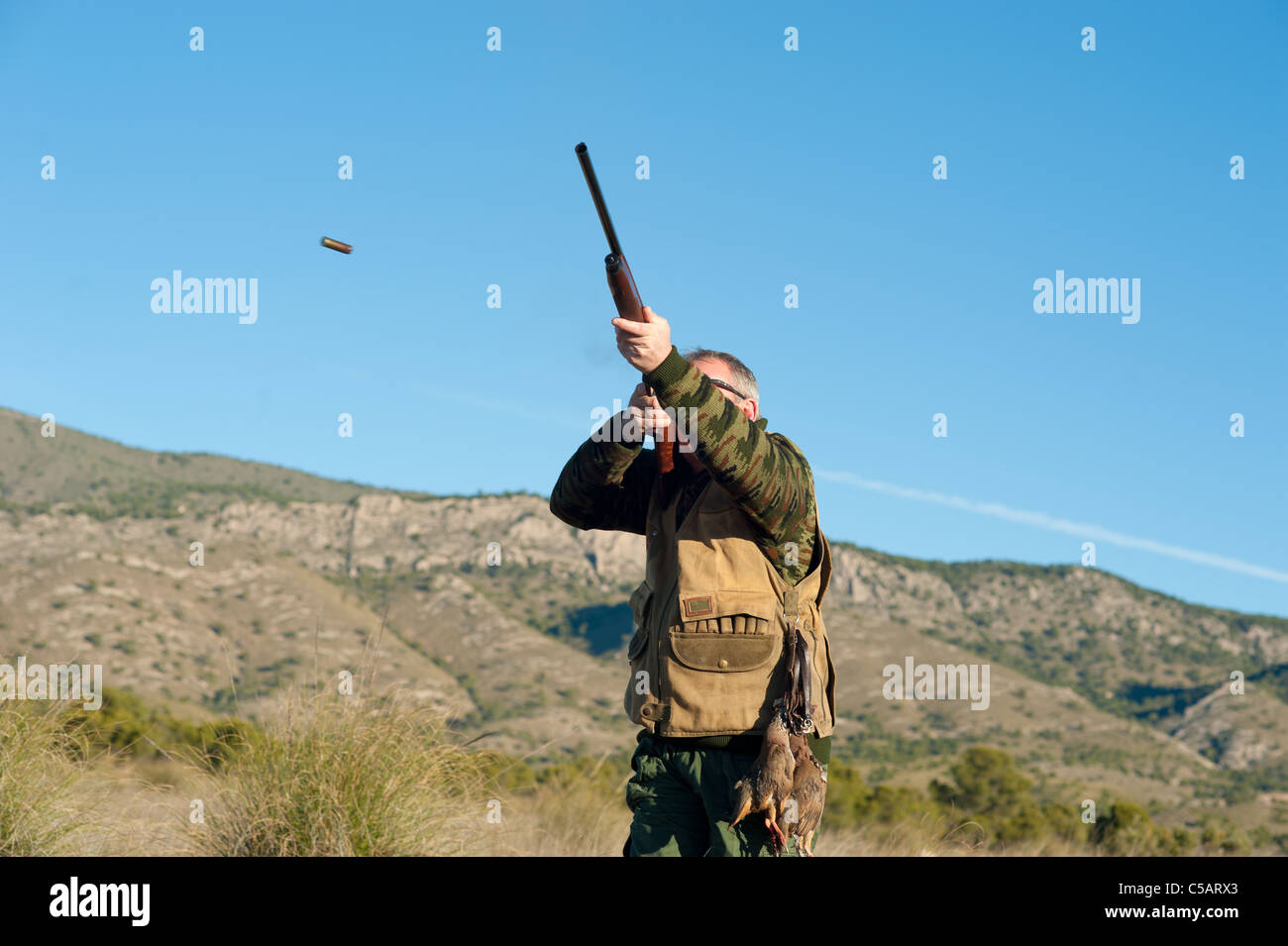 Hunter in action aiming and shooting his rifle Stock Photo - Alamy