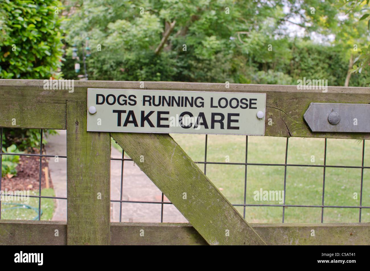 Dogs running loose, take care - sign on a garden gate Stock Photo - Alamy