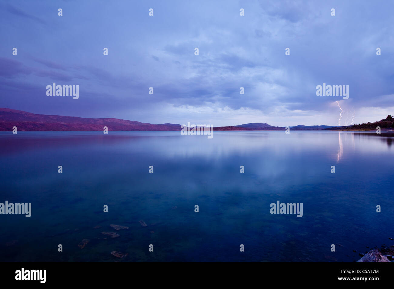 Lightning strike over lake at sunset Stock Photo - Alamy