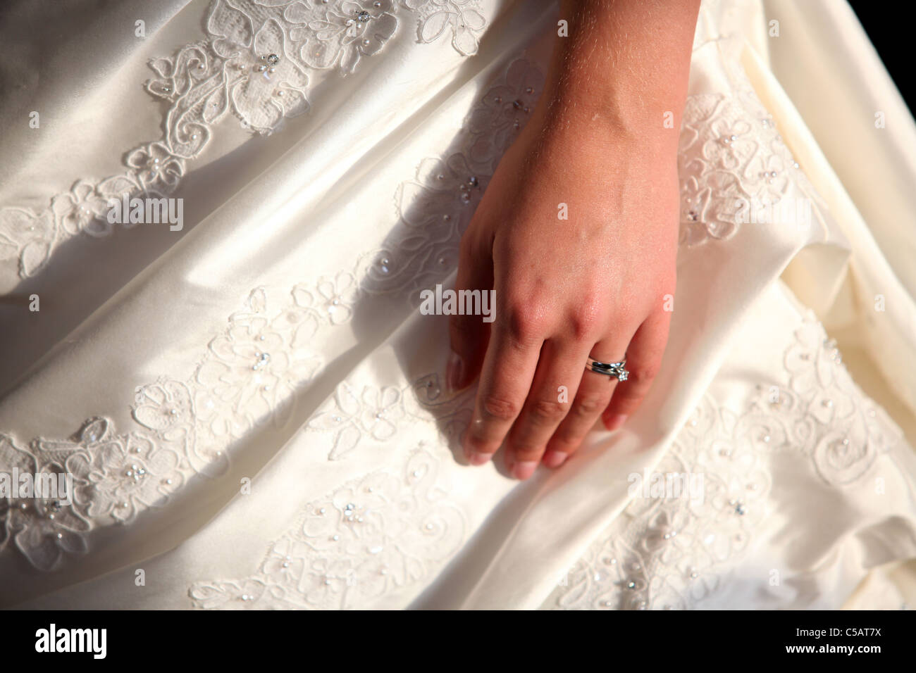 A bride's hand pictured against the wedding dress Stock Photo - Alamy