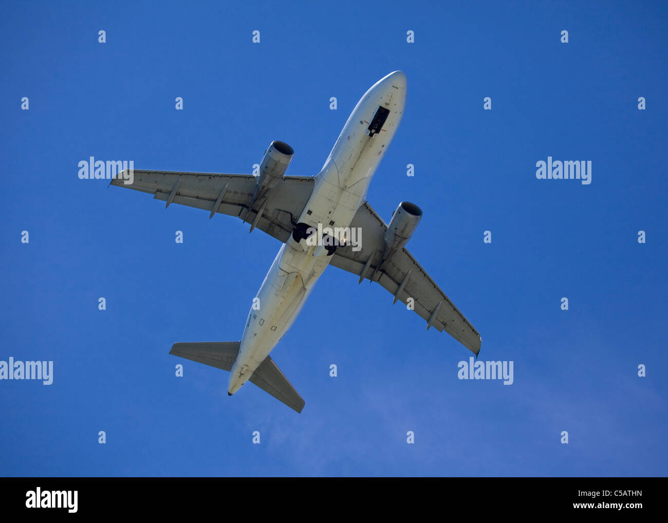 Bottom view commuter jet airplane against blue sky Stock Photo - Alamy