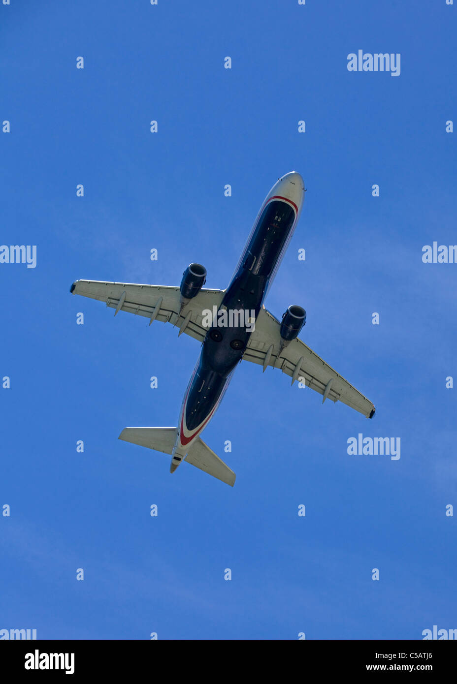 Bottom view commuter jet airplane against blue sky Stock Photo - Alamy