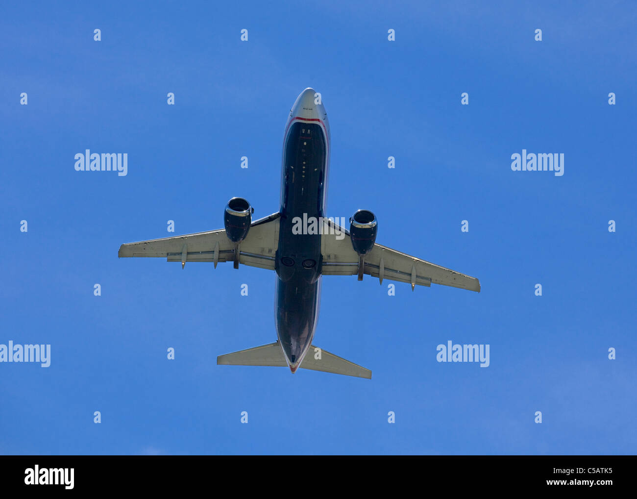 Bottom view of commuter jet against blue sky Stock Photo - Alamy