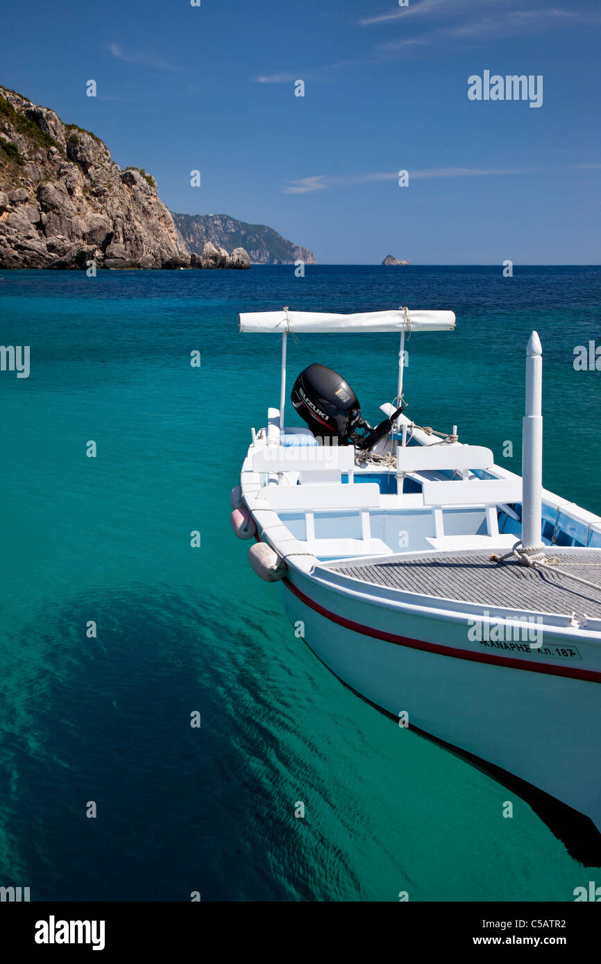 Boat floating in the clear water near Paleokastritsa on the Ionian ...