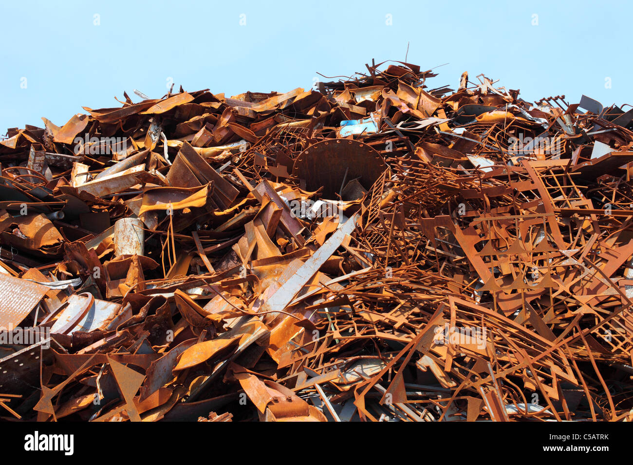 Stack of scrap metal against blue sky Stock Photo - Alamy
