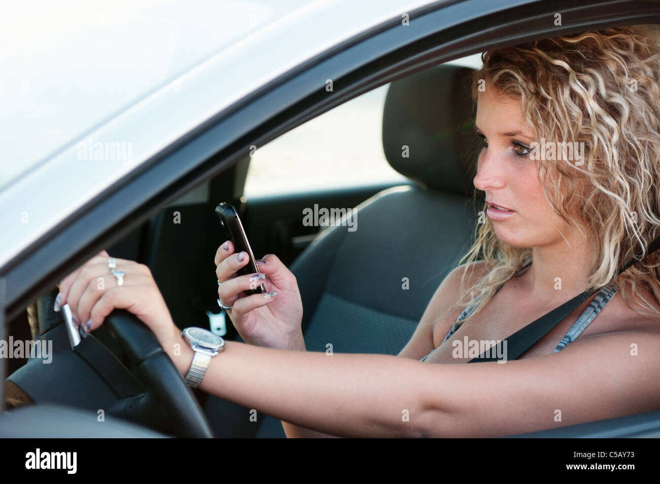 Reading SMS while driving car Stock Photo - Alamy