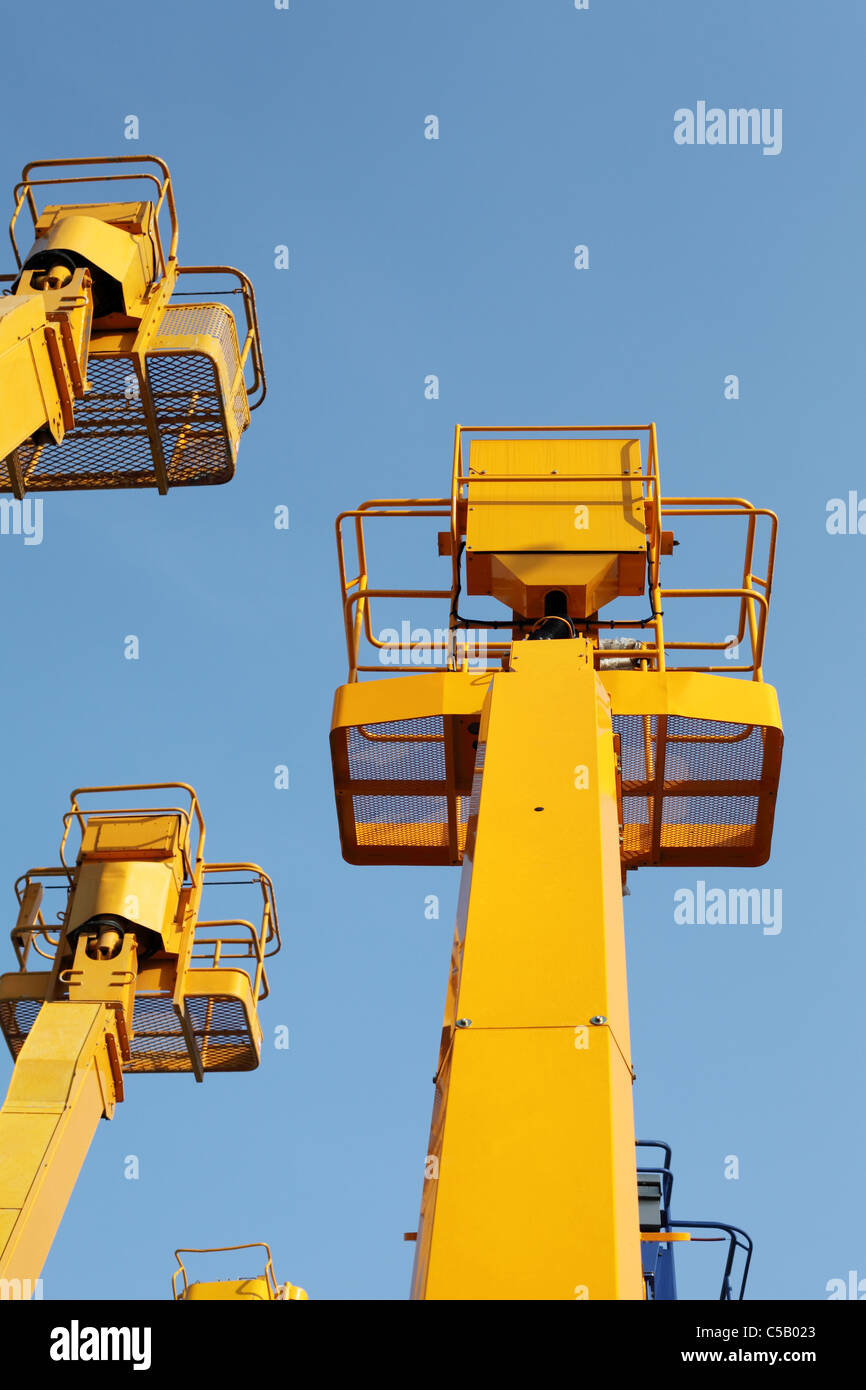 Yellow cherry picker against a blue sky Stock Photo - Alamy