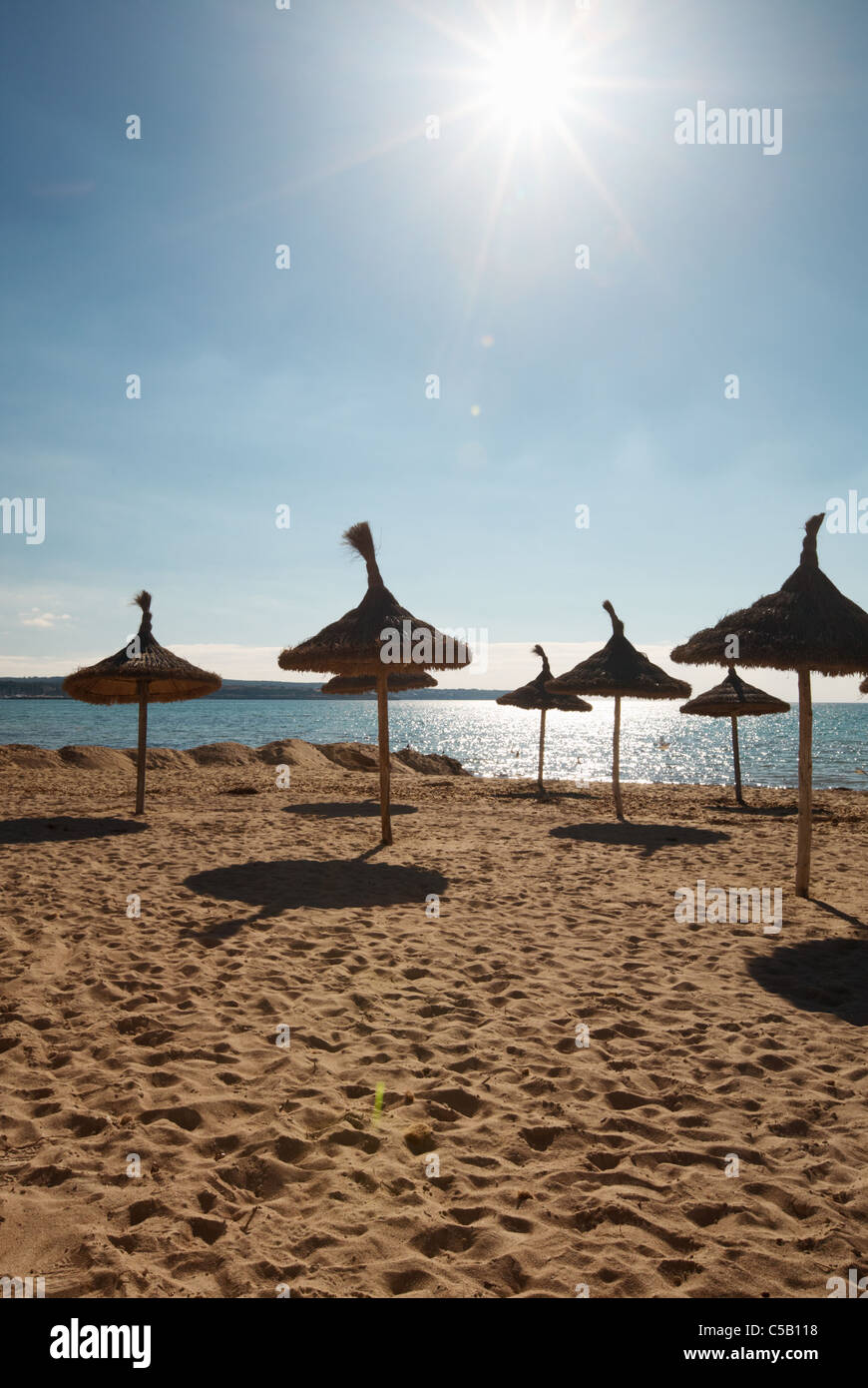 Empty beach with thatched beach umbrellas, Majorca, Balearic Islands ...