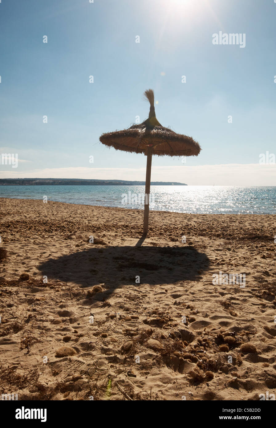 Empty beach with thatched beach umbrella, Majorca, Balearic Islands ...